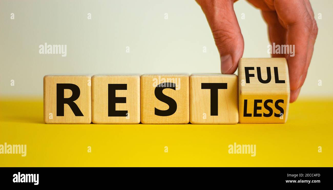 Restless or restful symbol. Businessman turns the wooden cube, changes ...