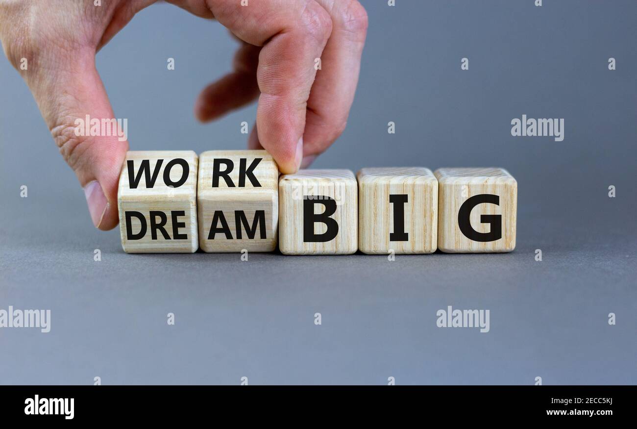 Work or dream big symbol. Businessman turns wooden cubes, changes words ...