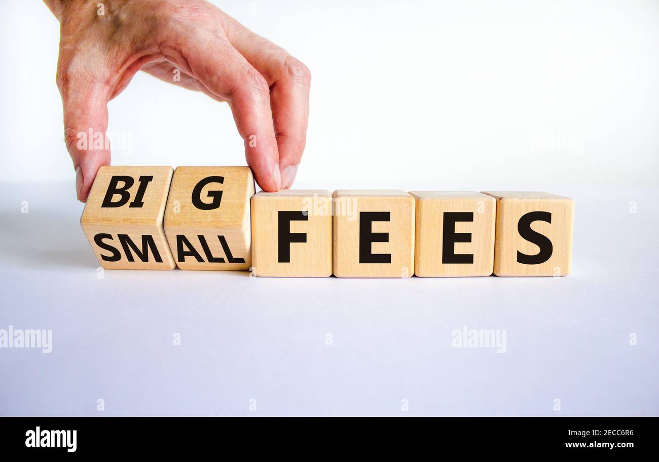 Big or small fees symbol. Businessman turns a wooden cube and changes ...