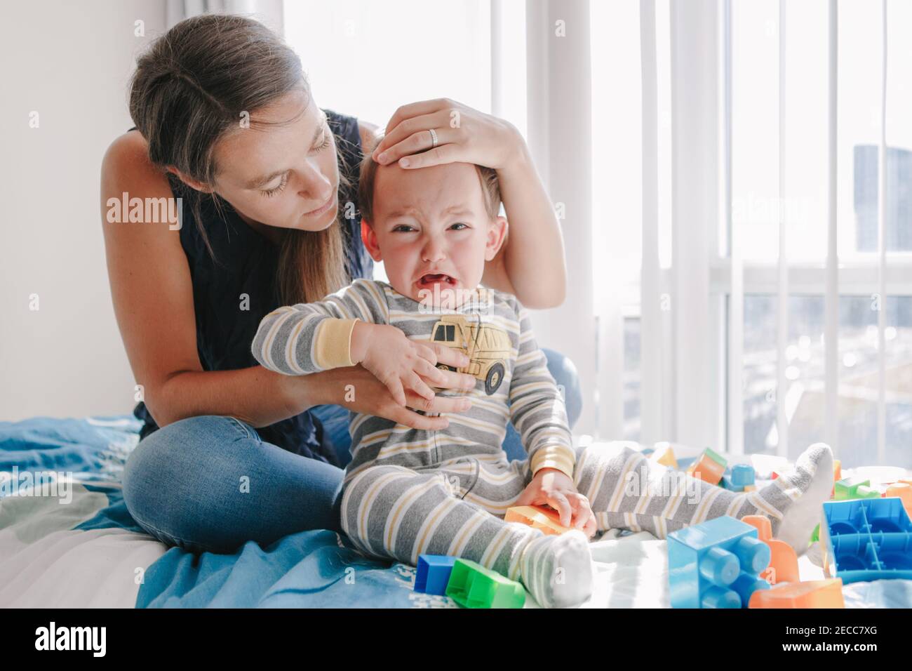 Mother hugging pacifying sad upset crying toddler boy. Family young mom ...