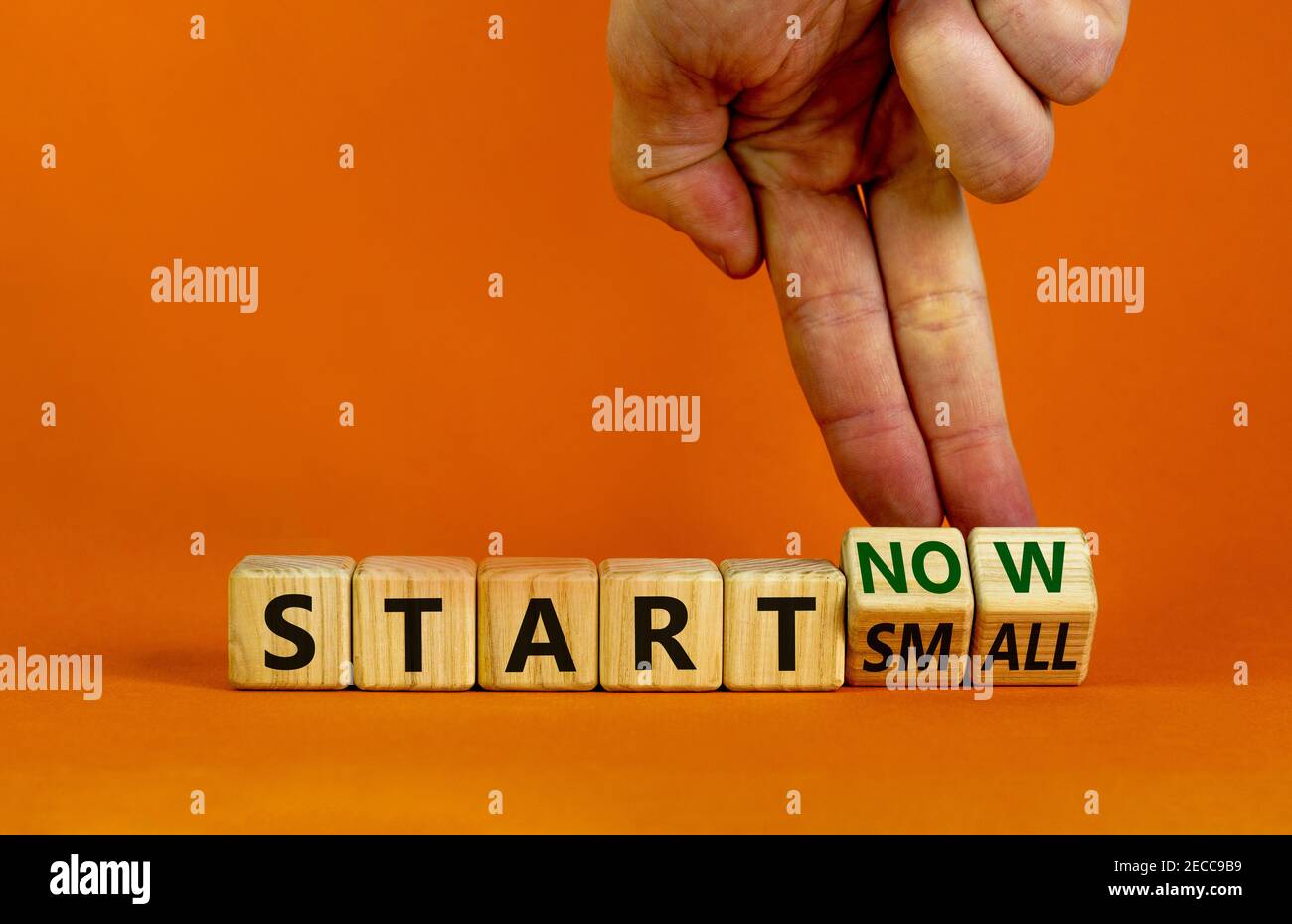 Start small and now symbol. Businessman turns wooden cubes and changes ...
