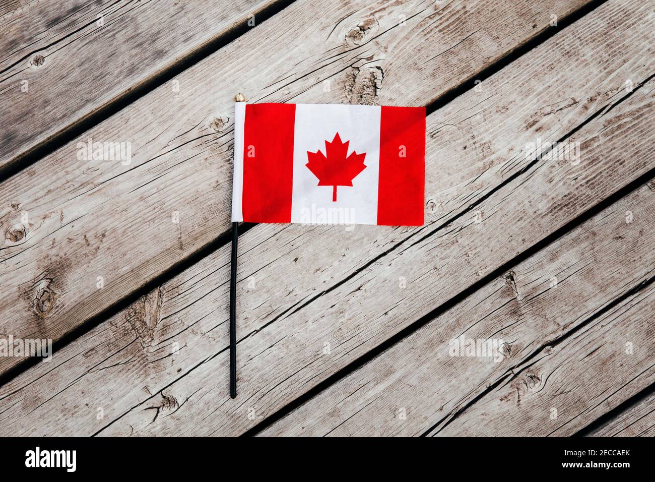 Red Canadian flag with red maple leaf on wooden planks background ...