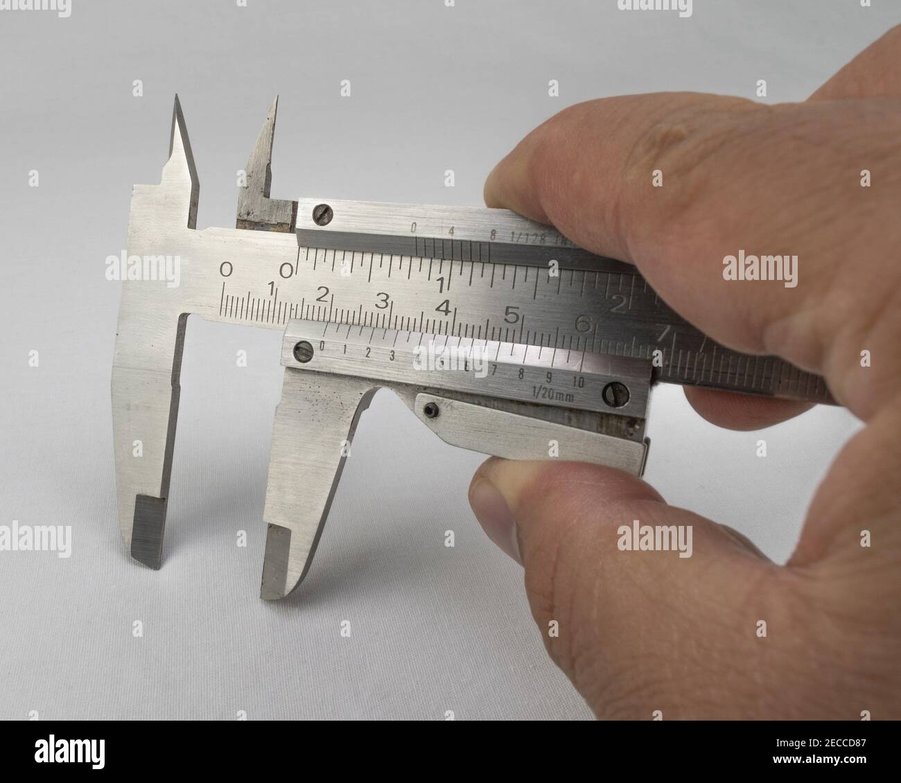 Technician's hand doing measurements with a caliper isolated on a white ...