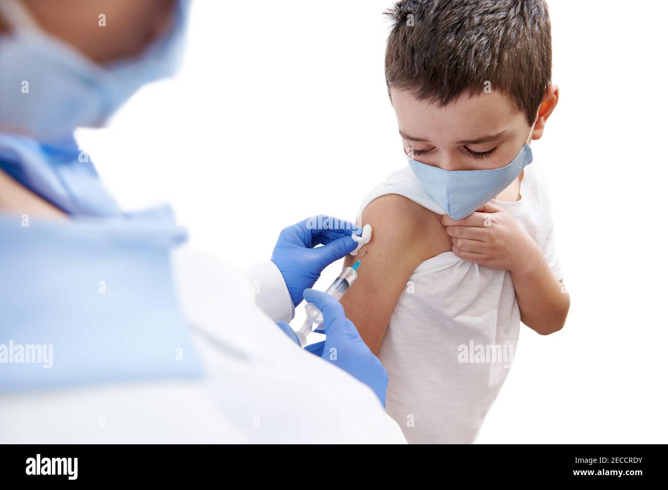 Scared boy looks at his hand while doctor vaccinating him. Isolated on ...
