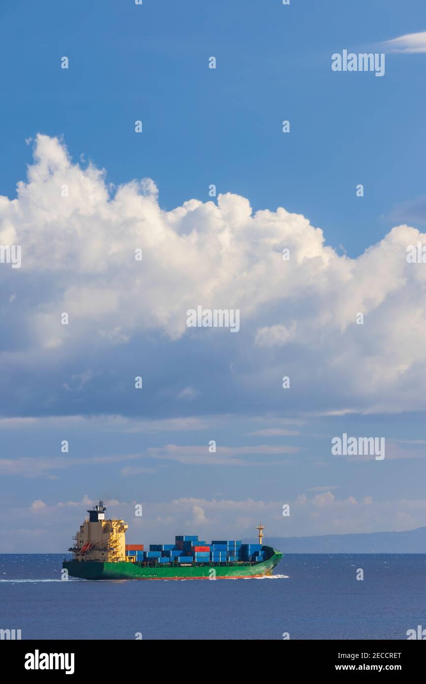 cargo ship nearby Capo Peloro Lighthouse in Punta del Faro on the ...