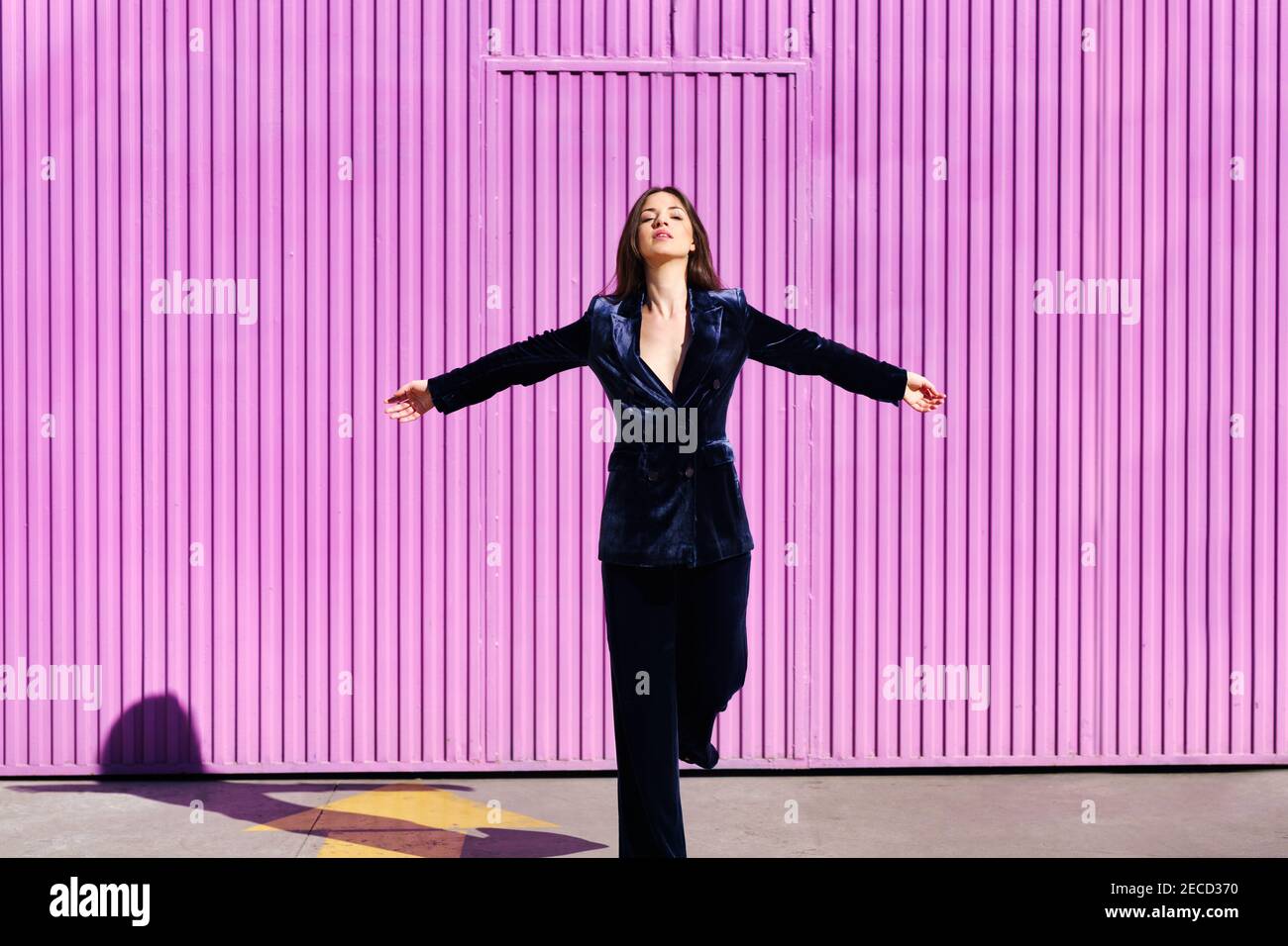 Woman wearing blue suit posing near pink shutter with open arms Stock ...