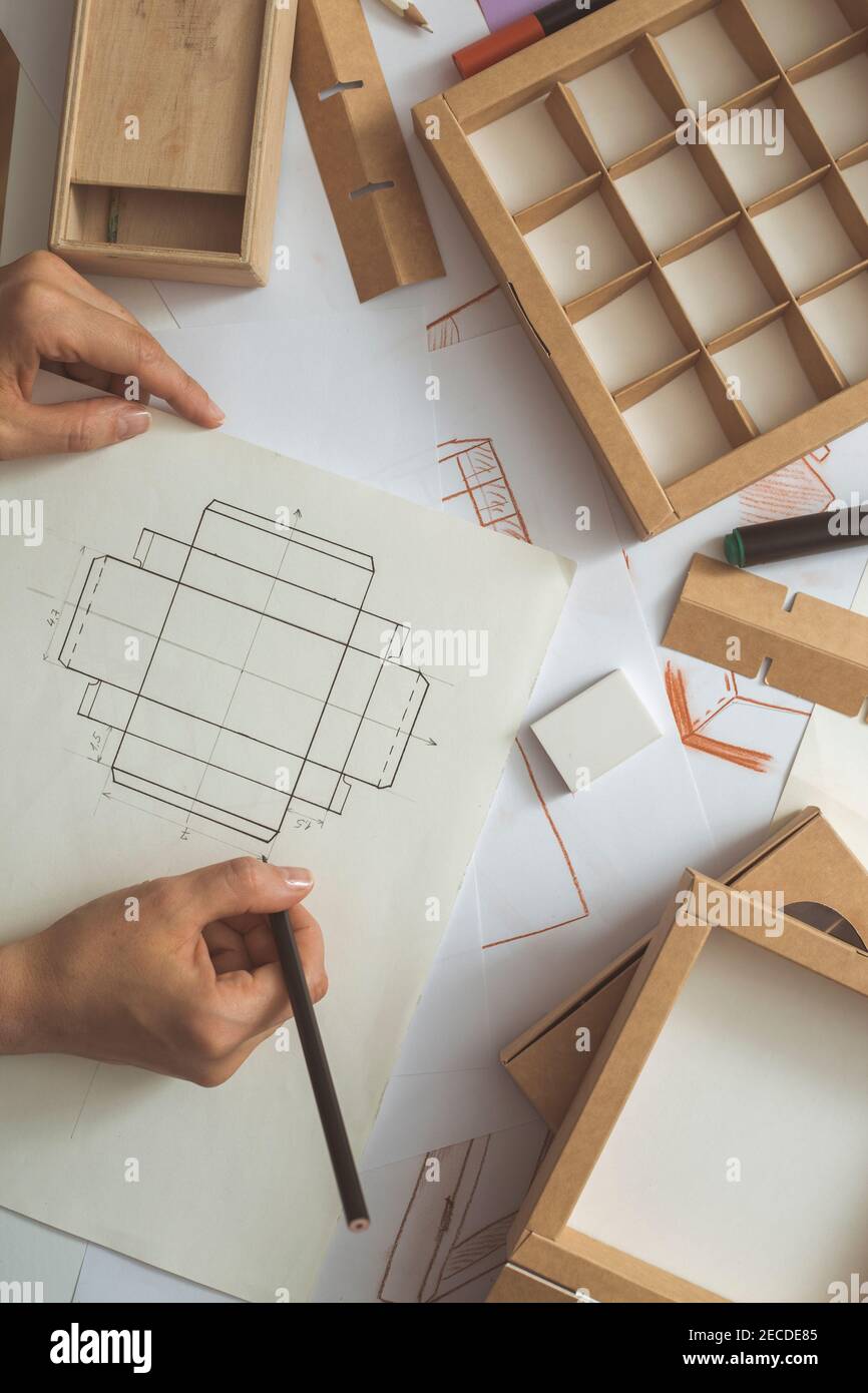 Designer draws a mockup for crafting cardboard box. Development of ...