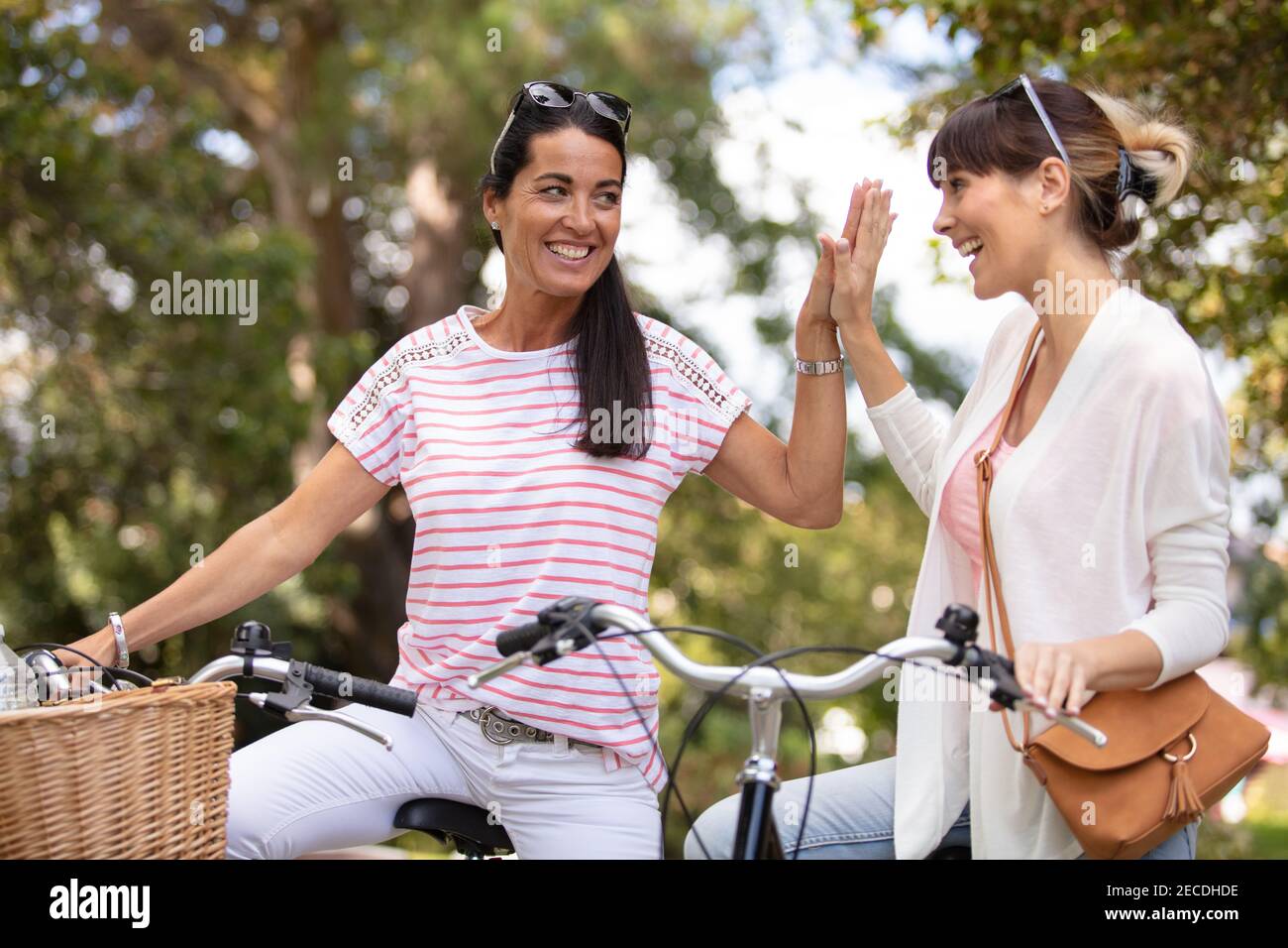 female cycling and giving each other a high five Stock Photo - Alamy
