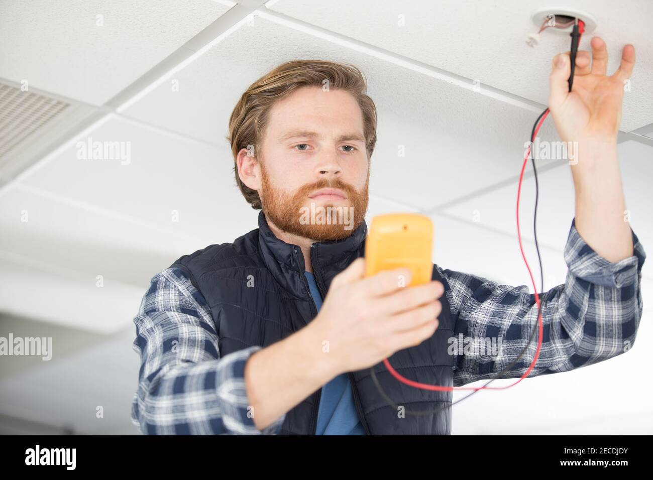 electrician testing spotlamp with a multimeter Stock Photo - Alamy
