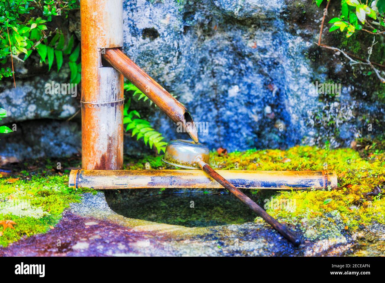 Traditional japanese drinking water pipe and dipper in Japanese garden ...