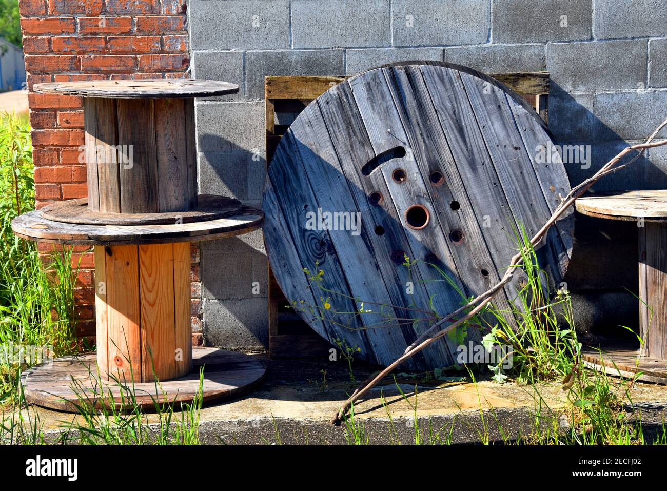 Empty, wooden cable spools are stacked against exterior wall of old ...