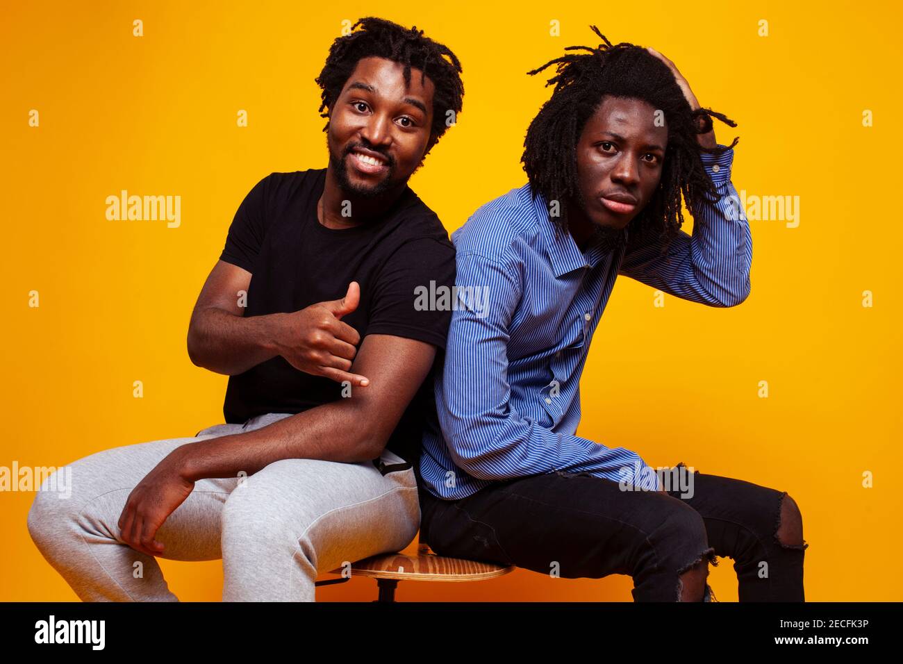 two african american guys posing cheerful together on yellow background ...