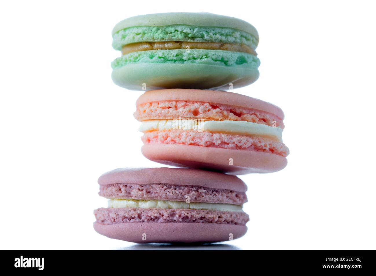 A close up stack of three macarons on an isolated white background ...