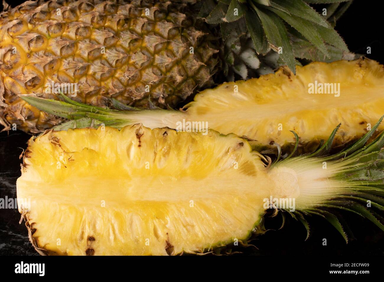 Pineapples split in half showing inside of the fruit Stock Photo - Alamy