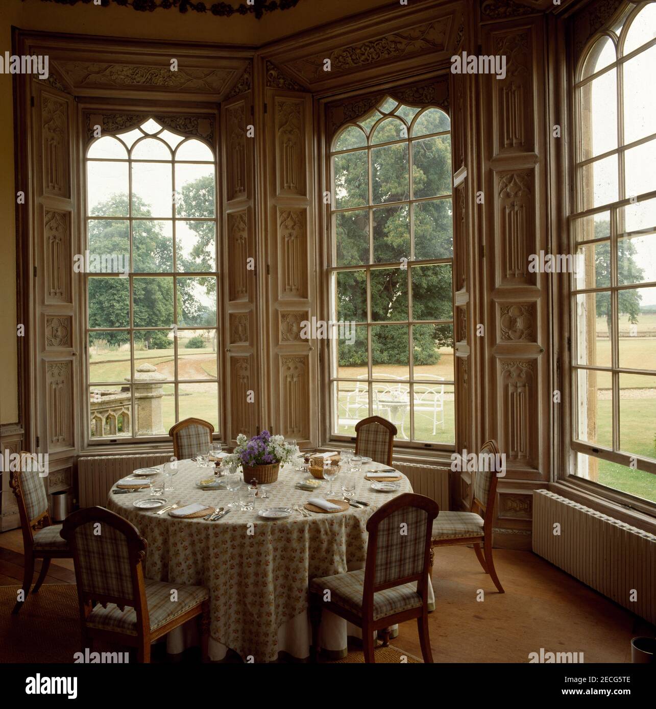 Round table set in bay window overlooking countryside Stock Photo - Alamy