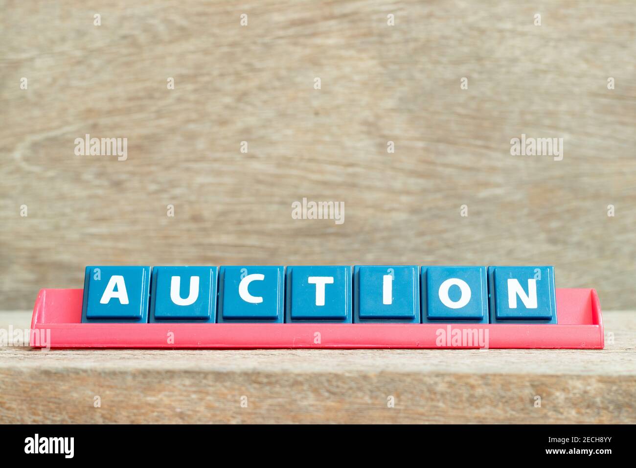 Tile alphabet letter with word auction in red color rack on wood ...