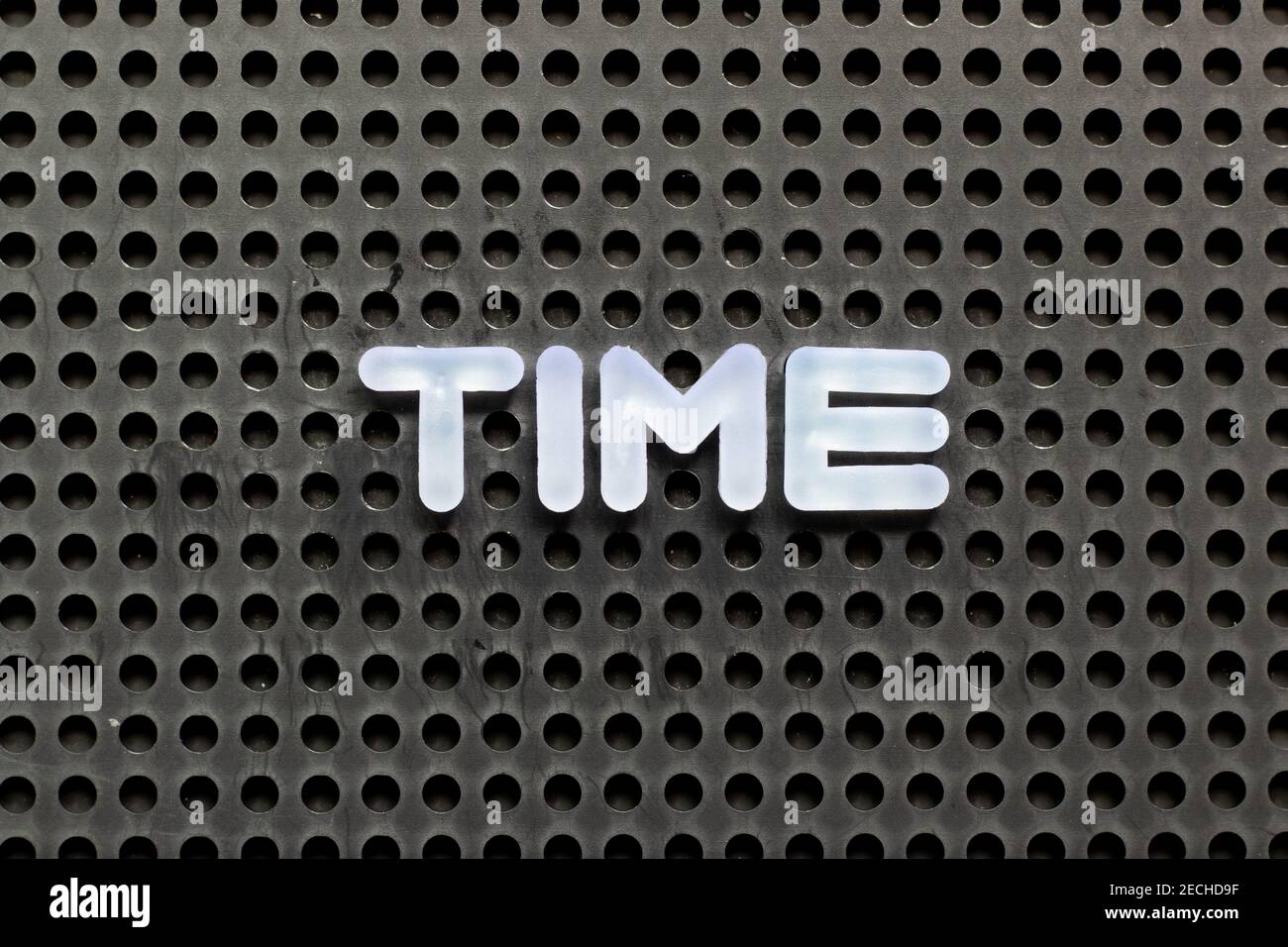 White color letter in word time on black pegboard background Stock ...
