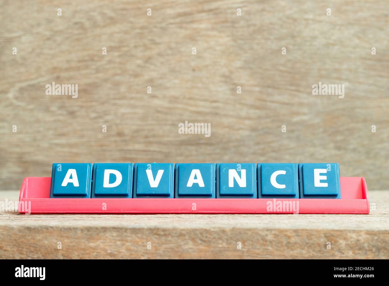 Tile alphabet letter with word advance in red color rack on wood ...
