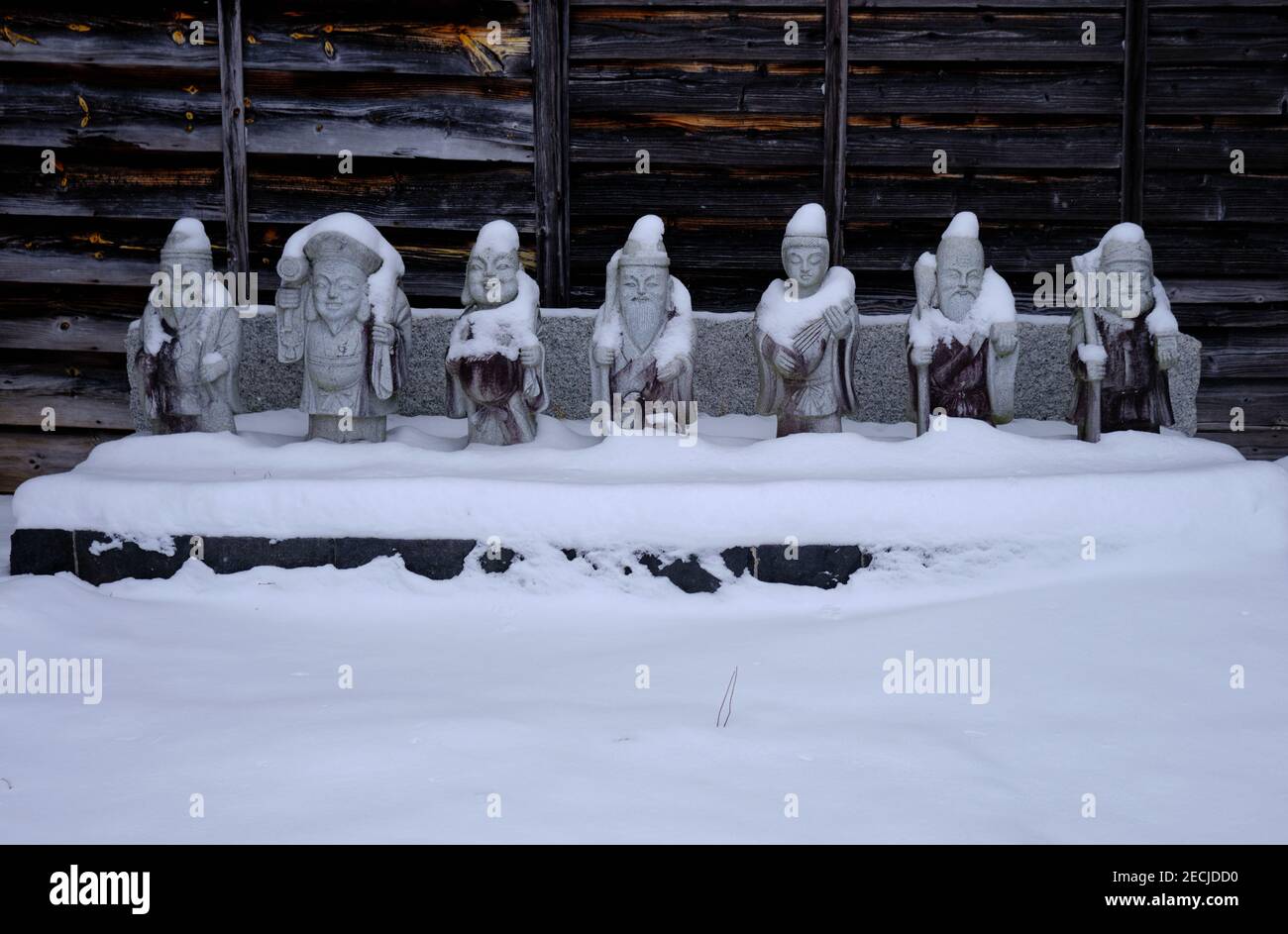Religious statues outside of Japanese temple covered in snow in winter ...