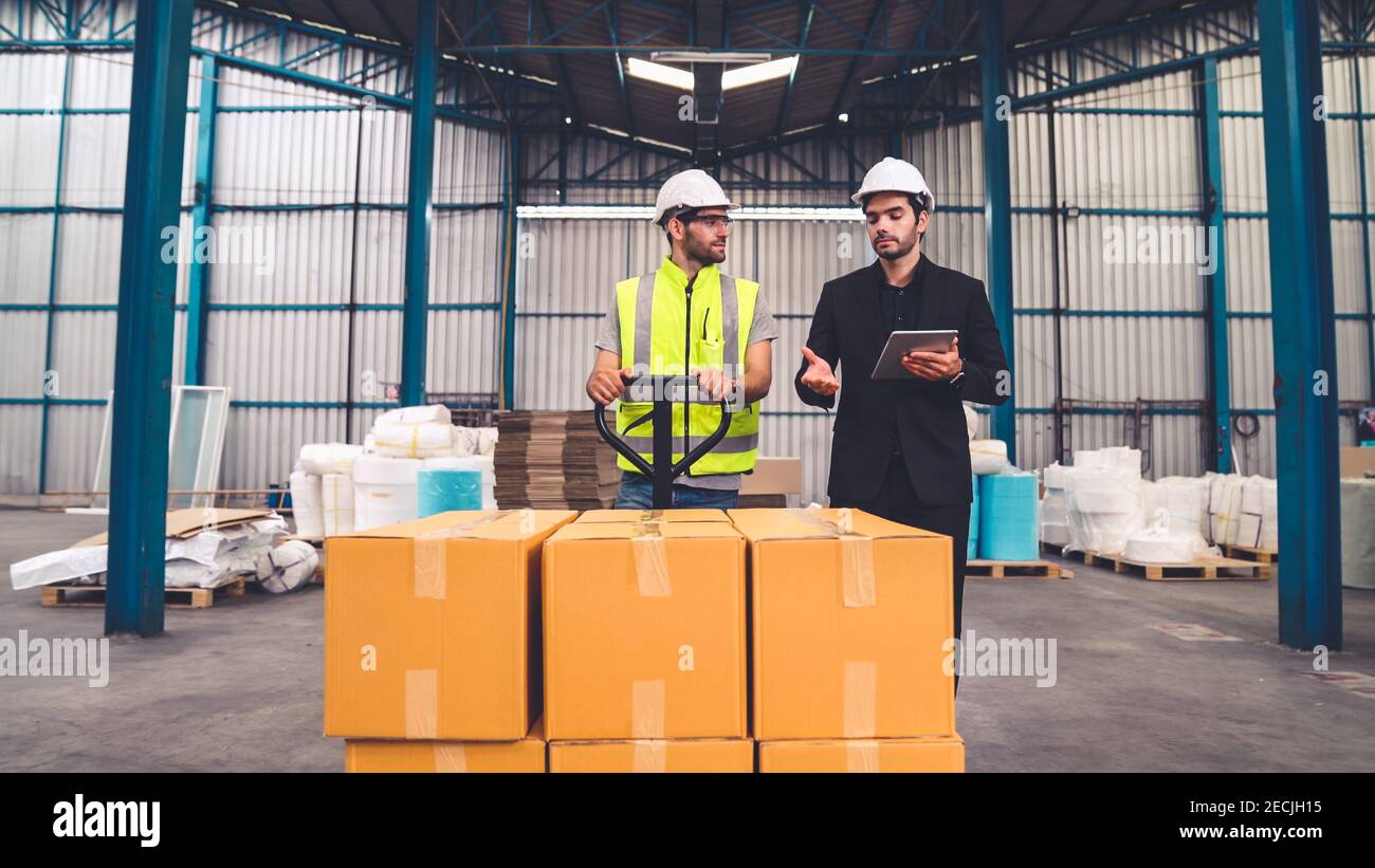 Factory workers deliver boxes package on a pushing trolley in the ...