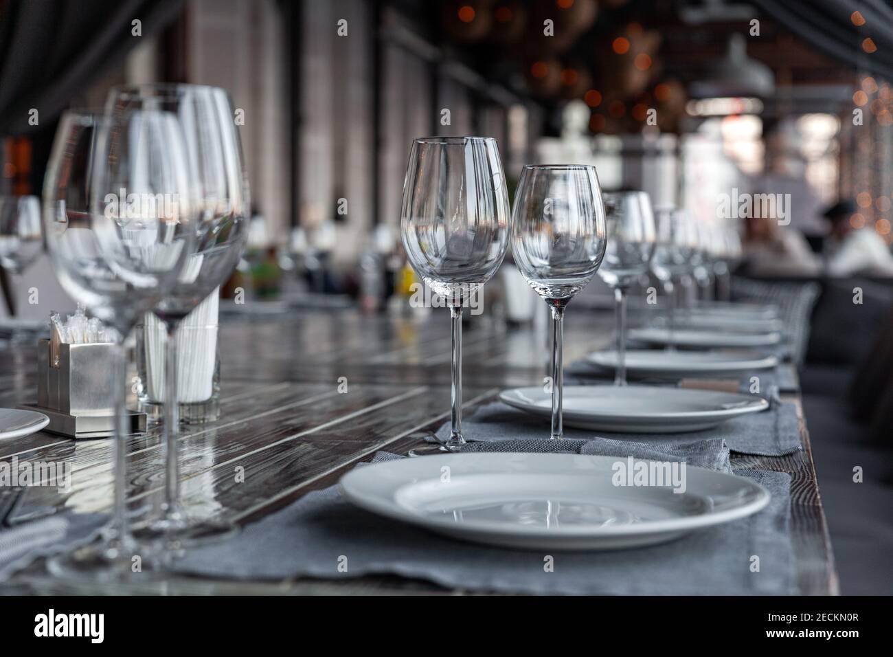 Modern veranda restaurant interior, banquet setting, glasses, plates ...