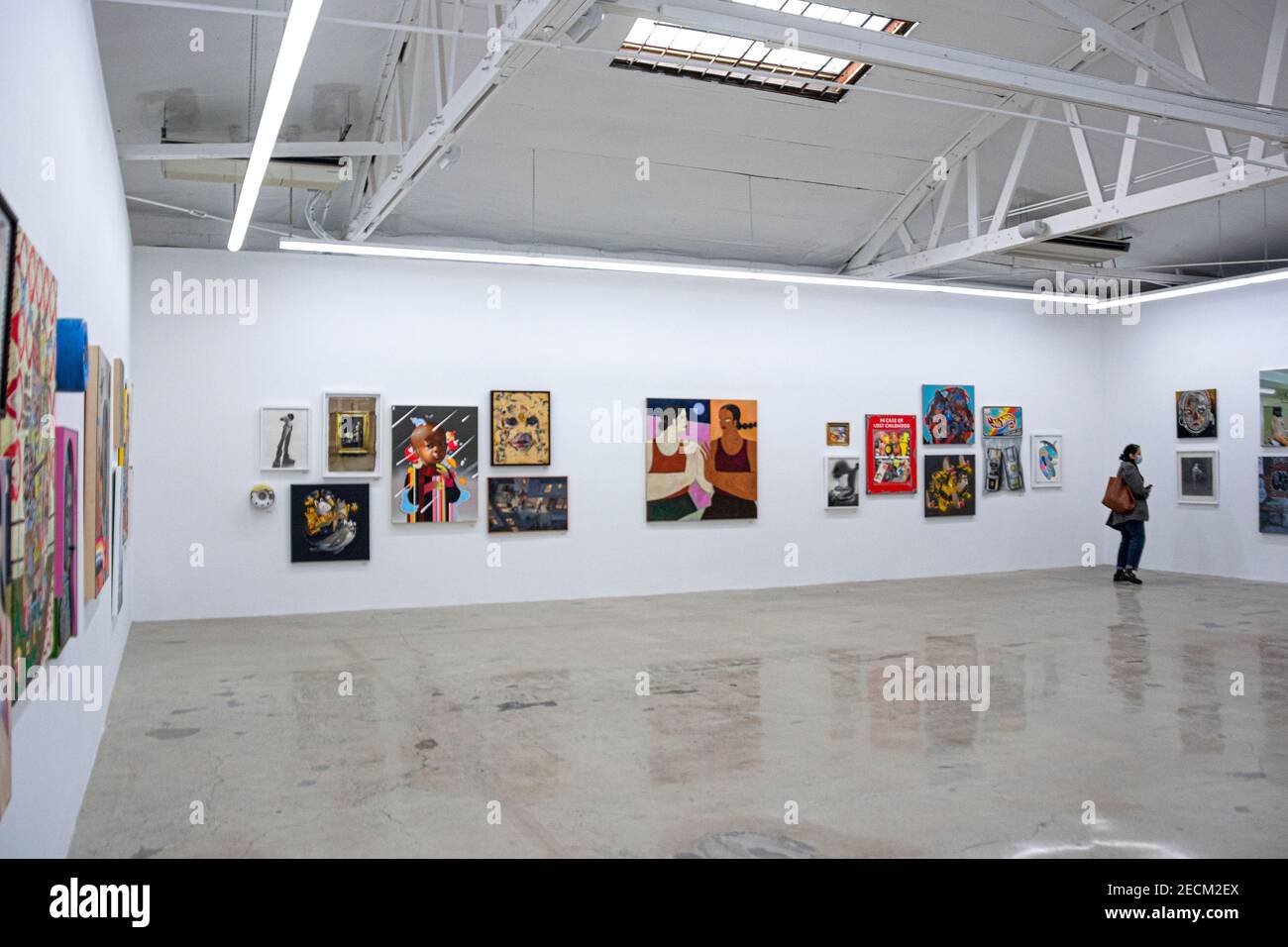 An art teacher, Emilia Leon, examining the various paintings being ...