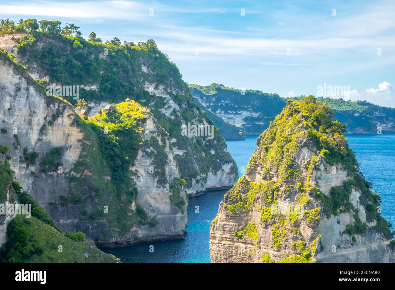 Ocean shore of the rocky island of Indonesia. A few huts on top of a ...