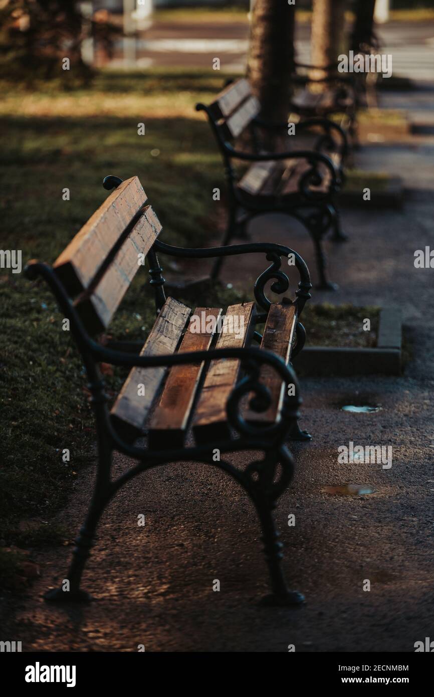 A vertical shot of wooden benches in a park Stock Photo - Alamy