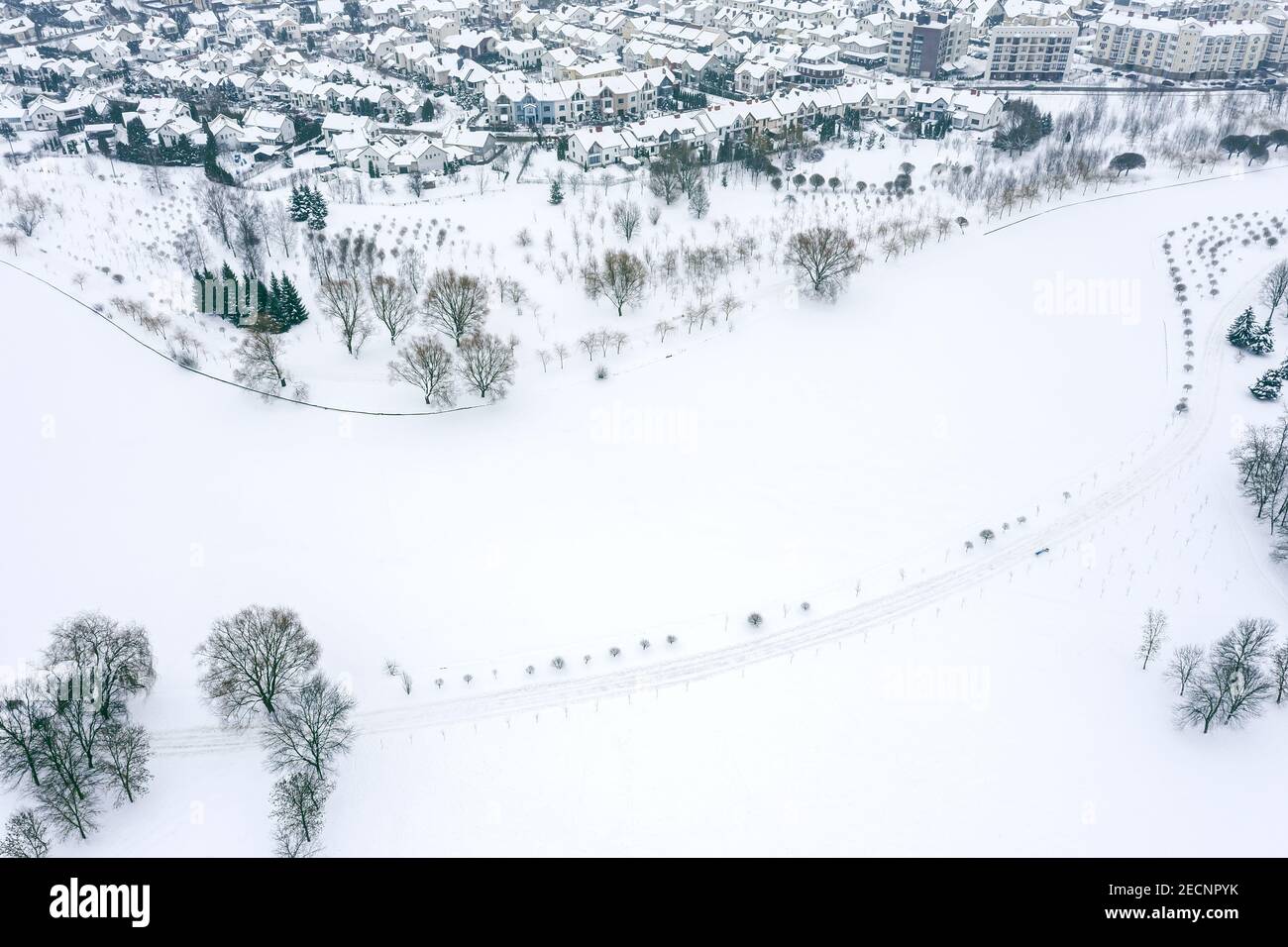 aerial view of small houses in snow-covered landscape near frozen river ...