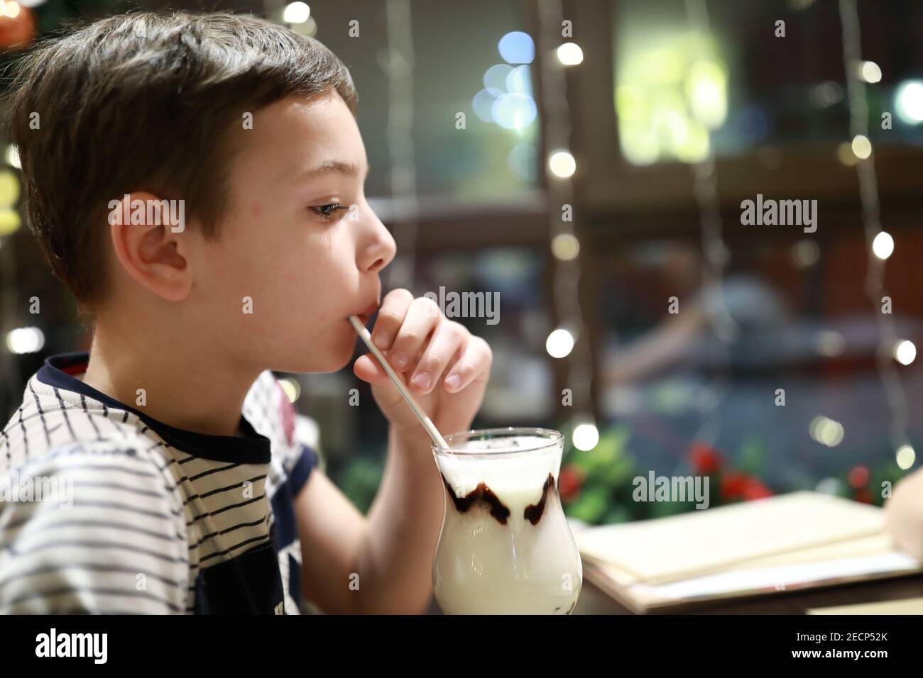 Boy drinking milk shake in a restaurant Stock Photo - Alamy