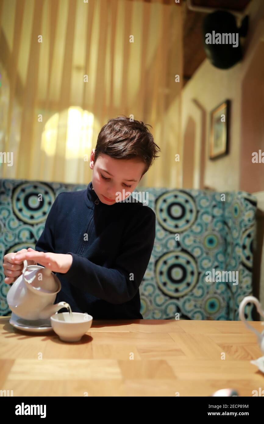 Portrait of kid pouring tea in restaurant Stock Photo - Alamy