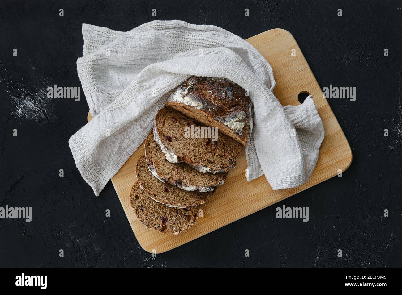 Overhead view of artisan freshly baked broun bread with raisins cut on ...