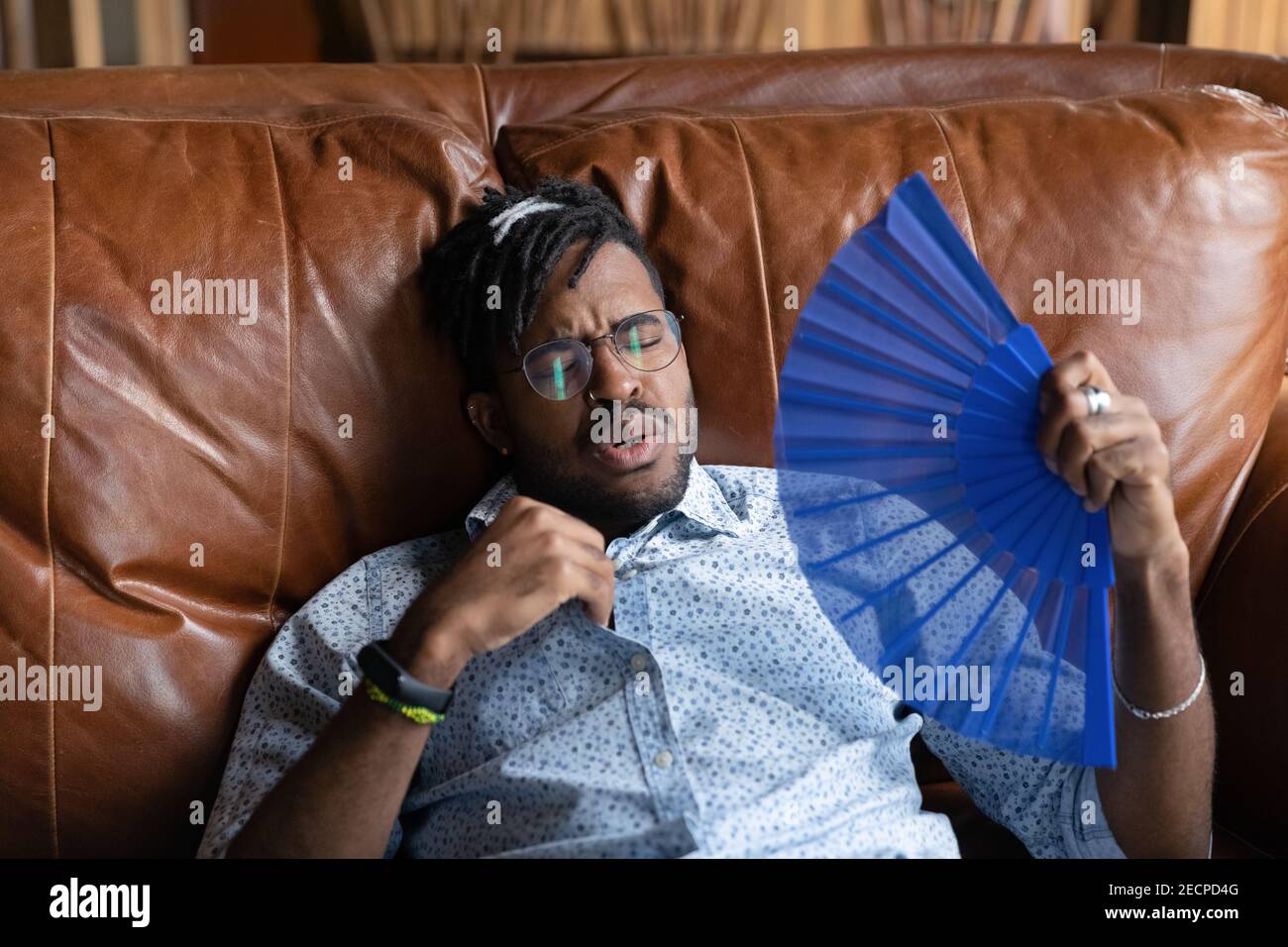 Close up exhausted African American man waving paper fan Stock Photo ...
