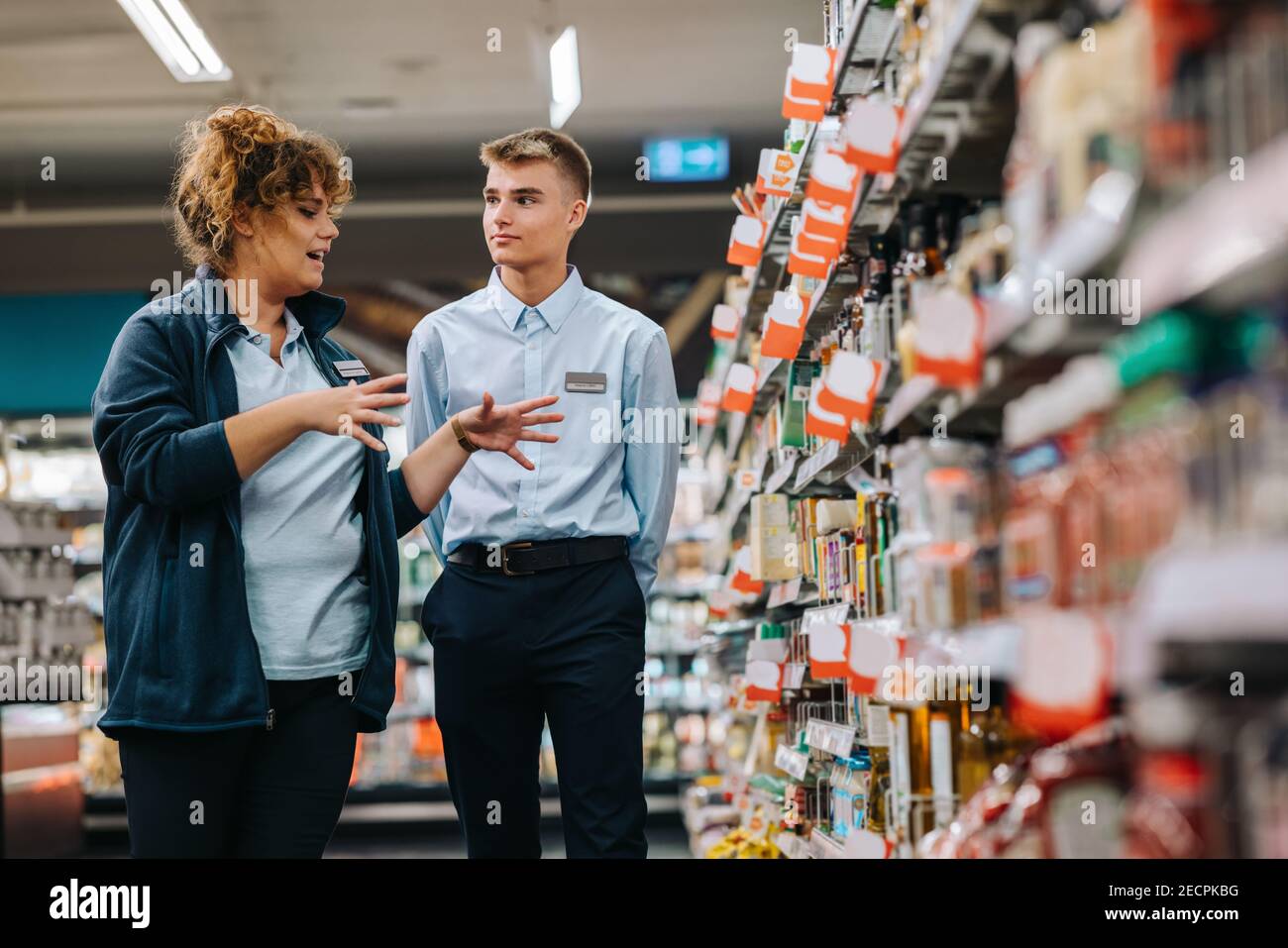 Store manager training young worker. Supermarket manager giving ...