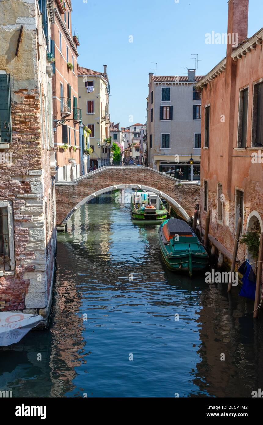 Venice cityscape, narrow water canal with boats, bridge and traditional ...