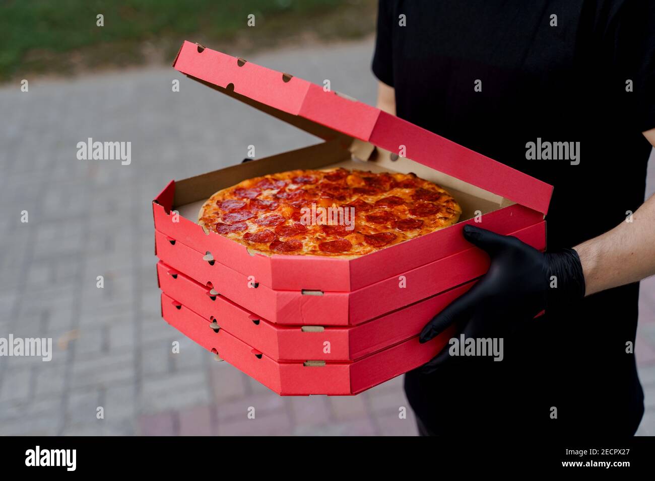 Safety pizza delivery from restaurant. Food courier in black medical ...