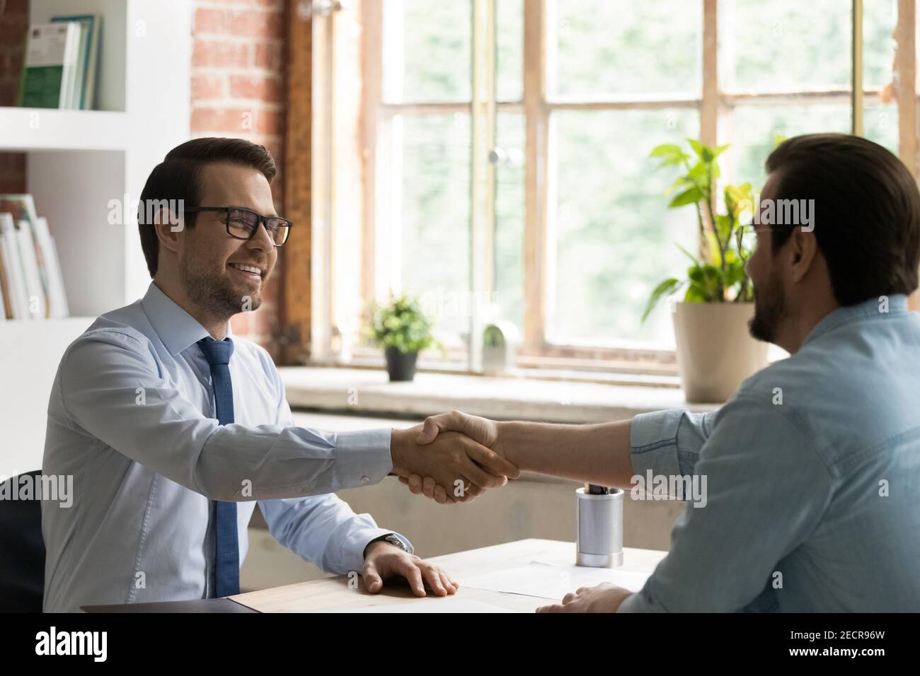 Smiling businessmen handshake closing deal at meeting Stock Photo - Alamy