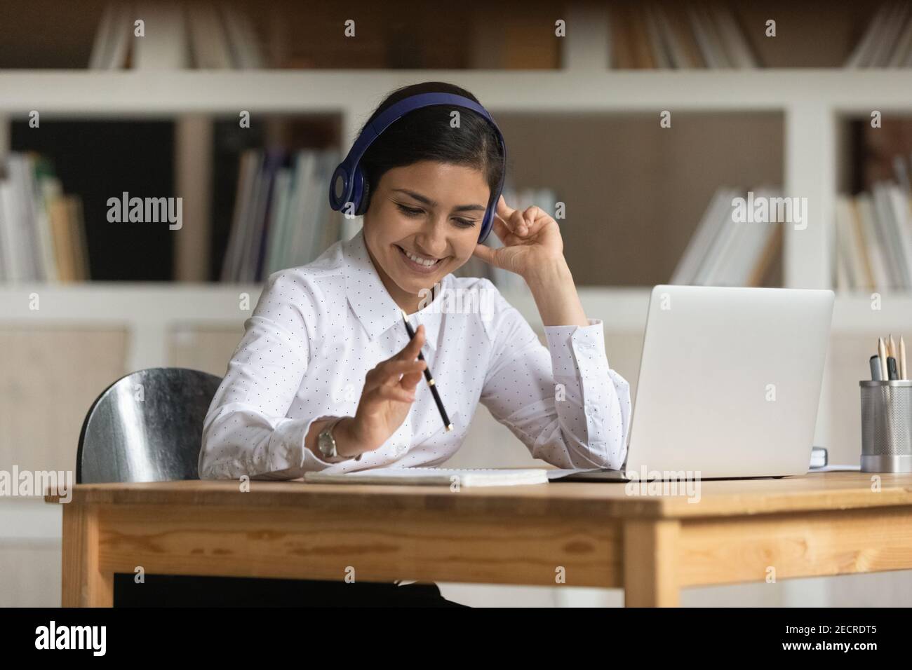 Smiling Indian female in headphones talk on video call Stock Photo - Alamy
