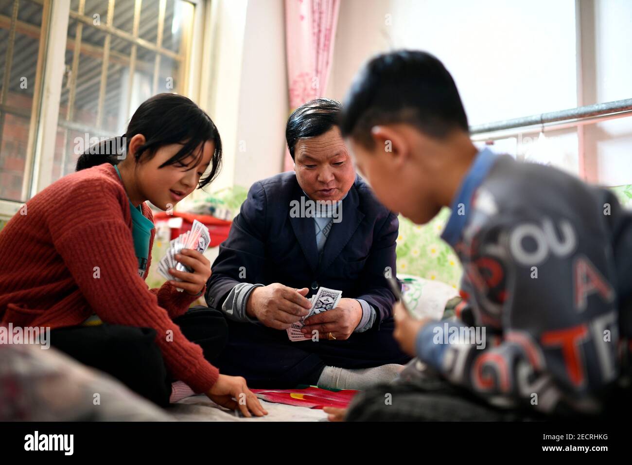(210214) -- YINCHUAN, Feb. 14, 2021 (Xinhua) -- Zhang Junming and family members play cards one ...