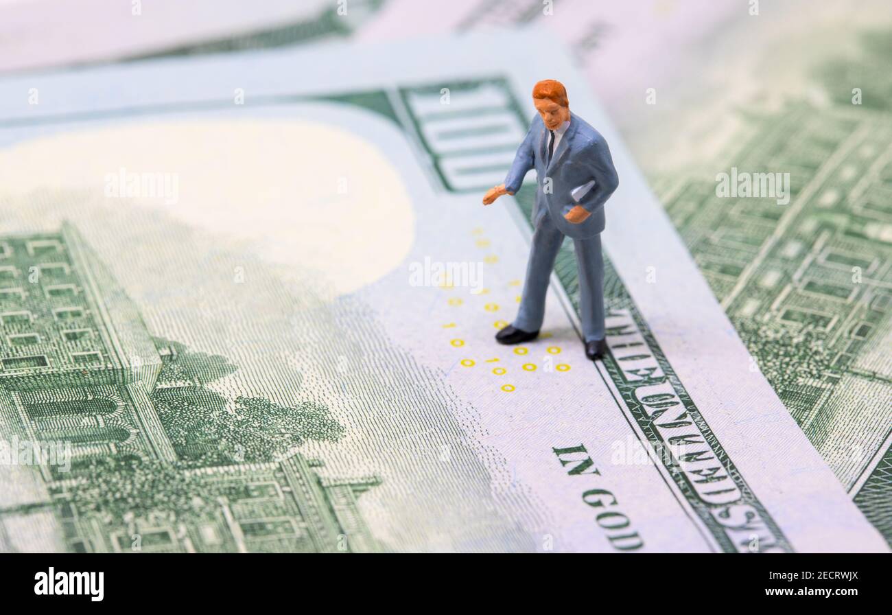 Businessman figurine on dollar banknote. Business man stand on money ...