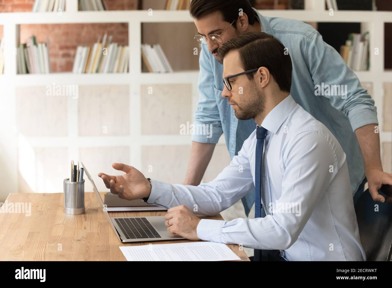 Serious male colleagues work on computer in office Stock Photo - Alamy