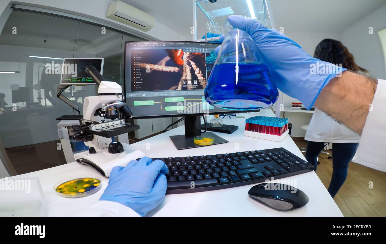 POV of scientist doctor doing research checking liquid from chemical ...