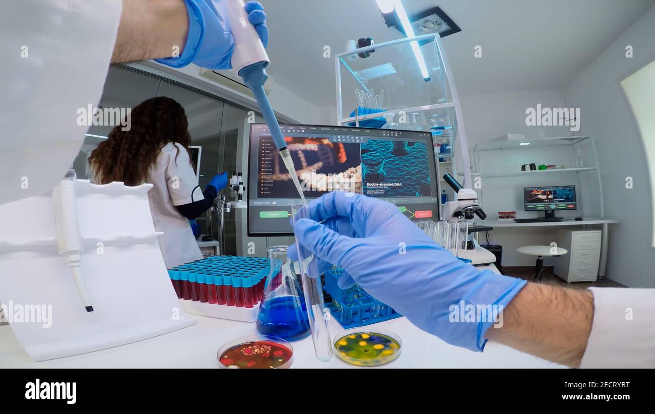 FPV of scientist using micropipette for filling test tube with liquid ...