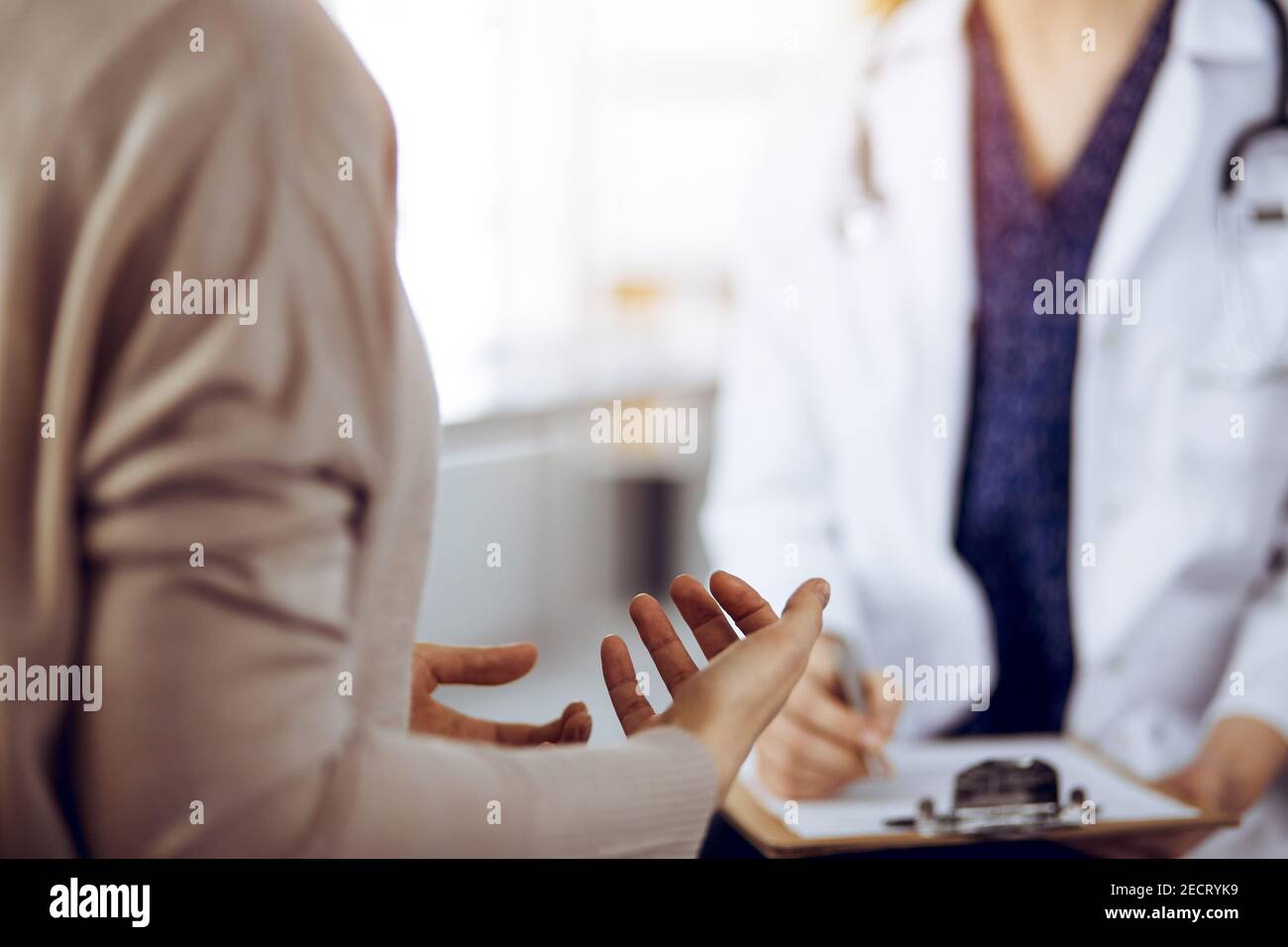 Doctor and patient discussing current health examination while sitting ...
