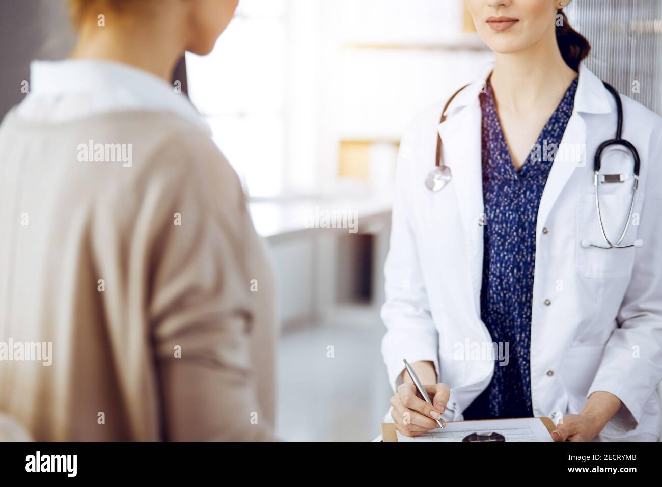 Doctor and patient discussing current health examination while sitting ...