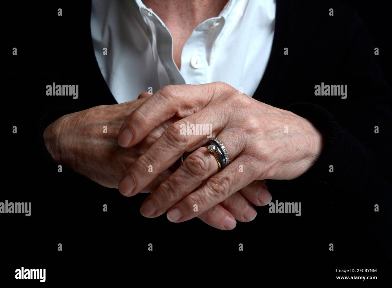 Hands resting calmly on a table with rings and an elegant shirt showing ...