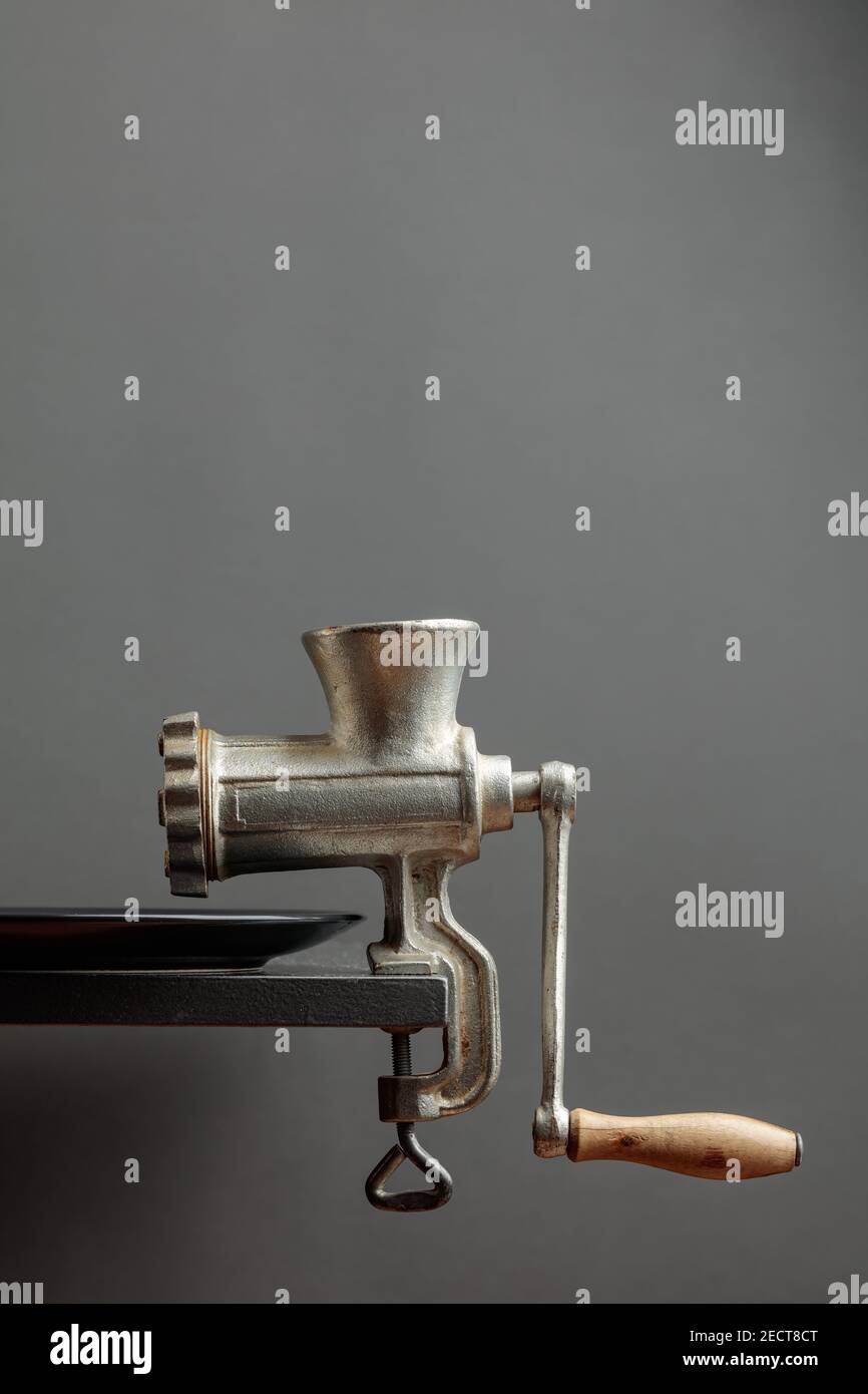 Old meat grinder on a grey background. Copy space Stock Photo - Alamy