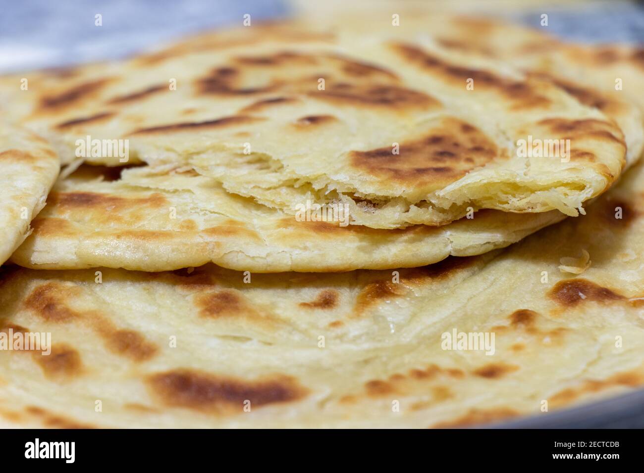 Fresh pita breads. Piece of bread is broken into two pieces. Selective ...