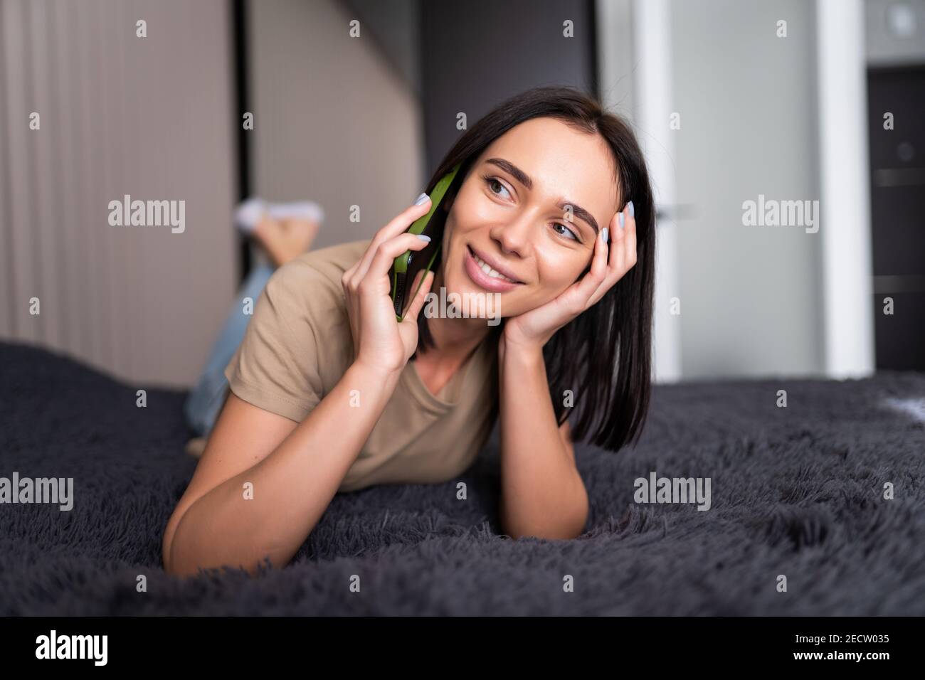 Young woman laying on the bed having a phone call Stock Photo - Alamy