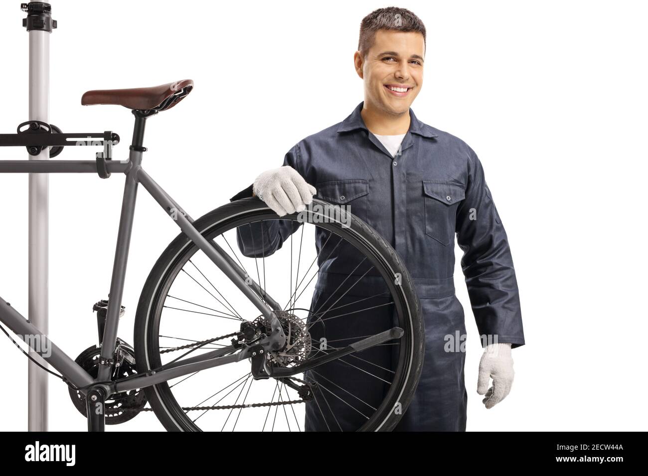 Bicycle mechanic fixing a bicycle wheel and looking at camera isolated ...